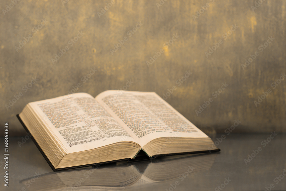 Bible on a glass dark table. Beautiful gold background.Religion concept ...
