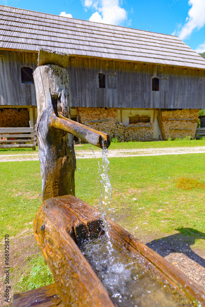 Traditional Wooden water trough, water well with trough in European ...