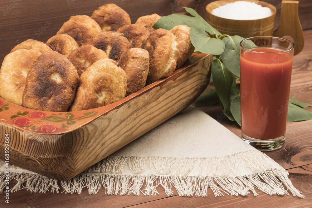 Rustic hot patty in a plate on a table with tomato juice and a napkin ...