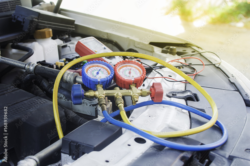 Poster Auto mechanic uses a pressure gauge on the air compressor,liquid ...