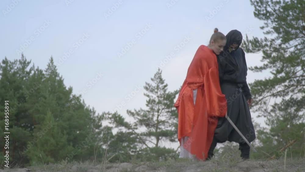 Stockvideo Geisha in a red kimono approaches a ninja with a katana ...
