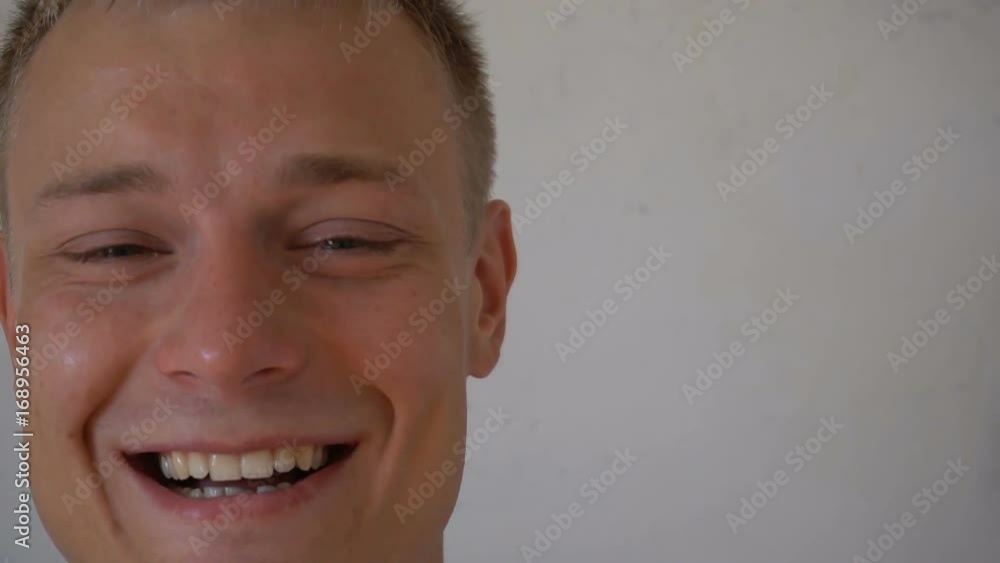 Closeup of smiling young man looking at camera isolated on white ...