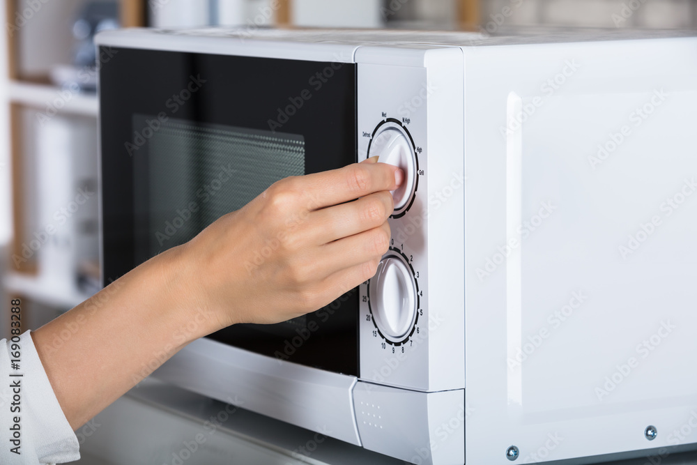 Woman Using Microwave Oven Stock Photo | Adobe Stock