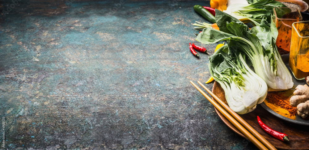 Asian cooking ingredients with pak choi and chopsticks on dark vintage ...