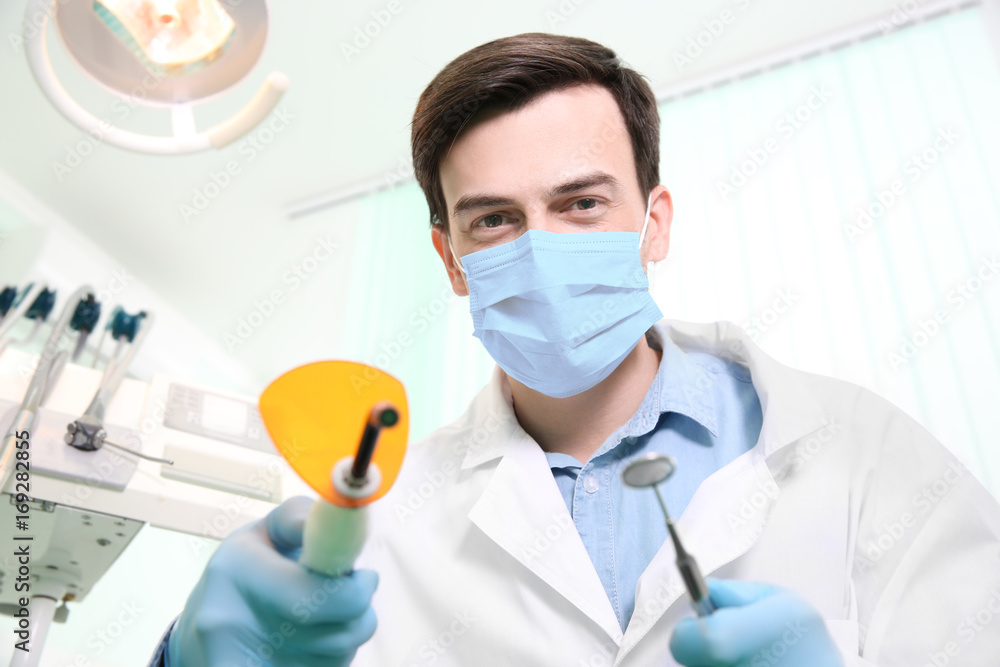 Male dentist with tools in clinic Stock-Foto | Adobe Stock
