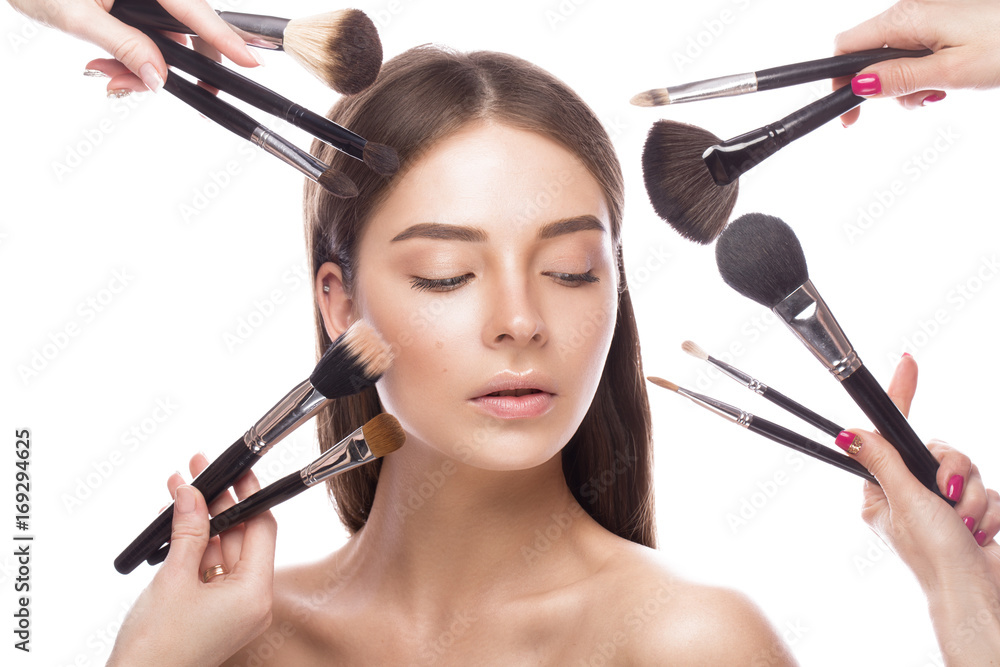 Beautiful young girl with a light natural make-up,brushes for cosmetics ...