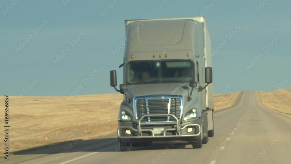 CLOSE UP: Unrecognizable grey semi truck driving directly into camera ...