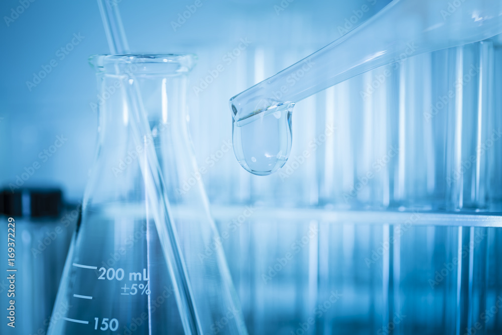 Close up the emerging drop of chemical solution from a dropper and ...