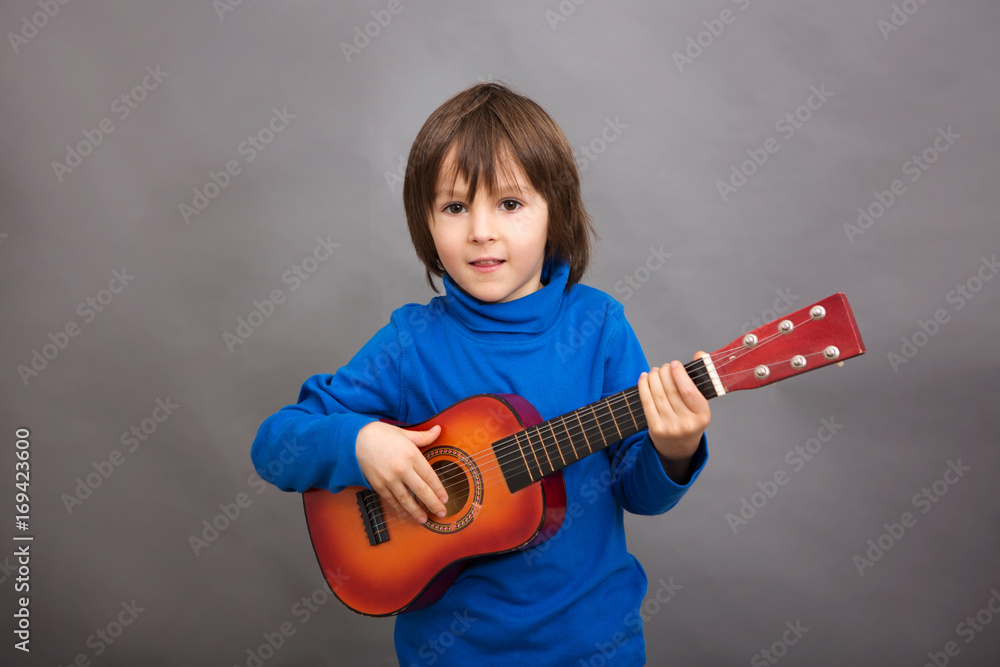 Preschool child, playing little guitar, isolated image Stock Photo ...