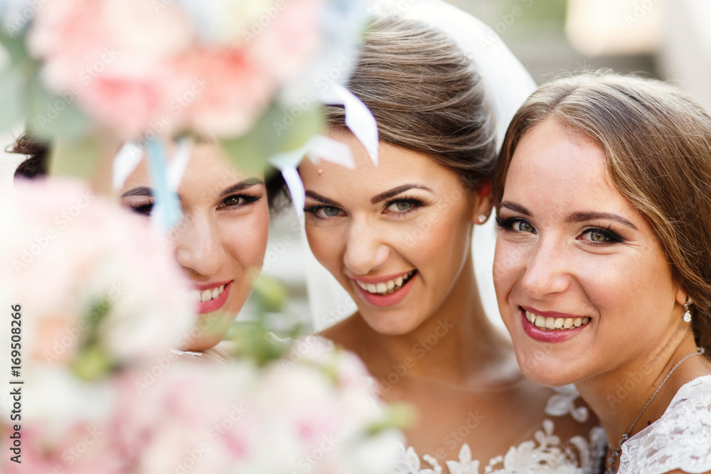 Charming smiles of bride and bridesmaids in lace gowns with wedding ...