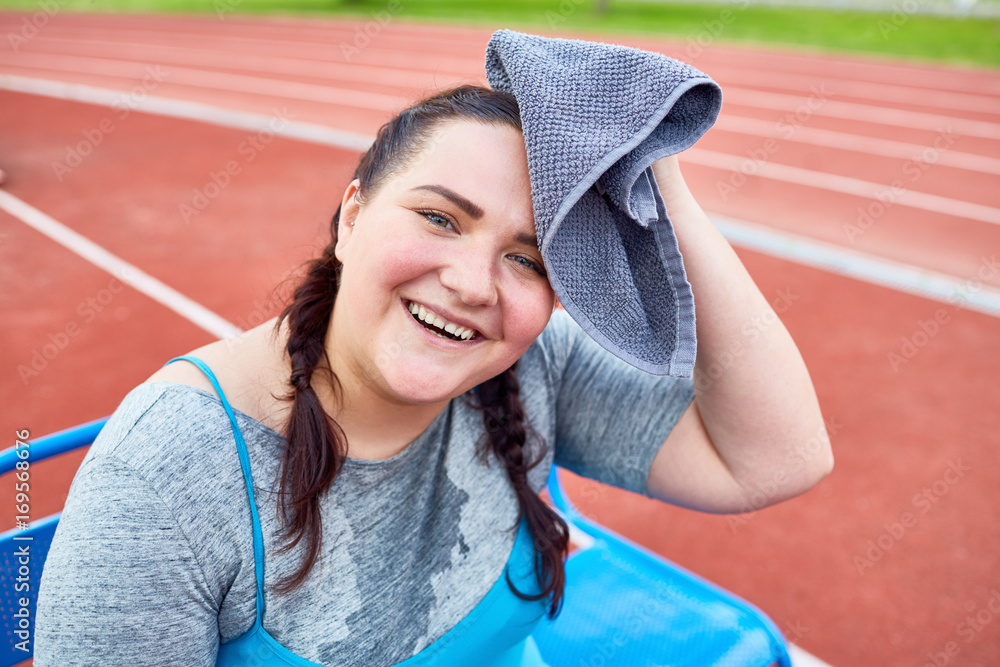 Sweaty and happy fat woman drying her forehead with towel after hard ...