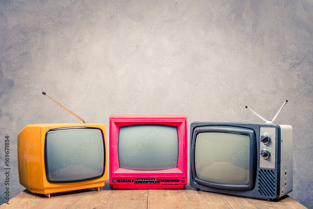 Retro old TV set receivers on table front textured concrete wall ...
