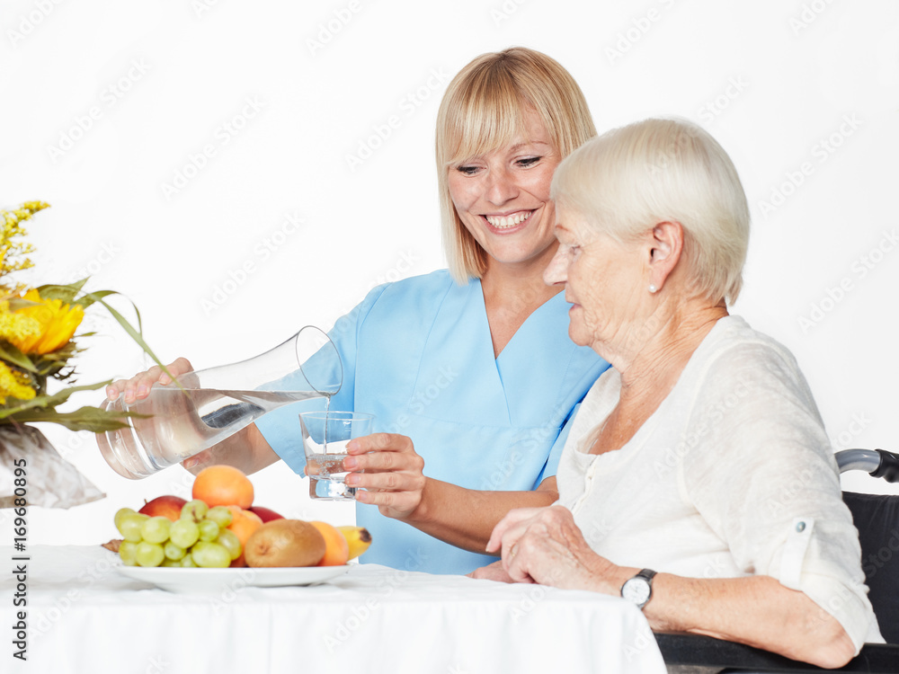 Altenpflegerin hilft Senioren beim Essen Stock-Foto | Adobe Stock