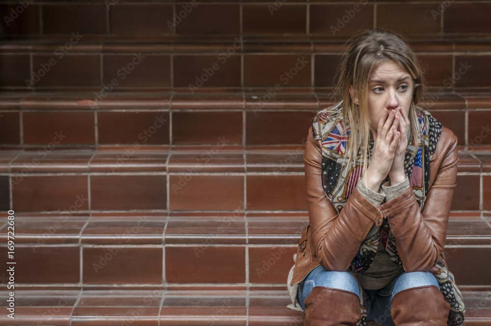 Sad girl sitting thoughtfully at the street Stock Photo | Adobe Stock