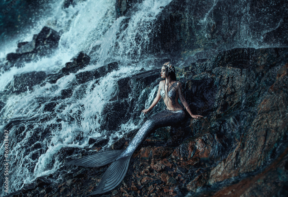 Foto de The real mermaid is resting on the ocean shore. Silver tail ...