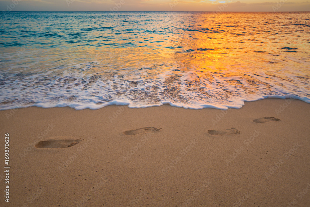 Footprints on beach sand with sea wave with foam at sunset time. Foot ...