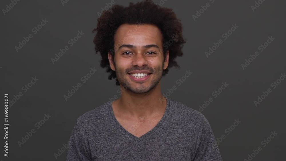 Dark skinned young man with afro haircut smiling with white teeth and ...