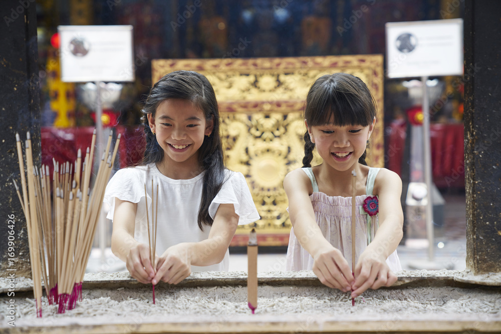 Two young girls placing their joss sticks in a temple Stock Photo ...