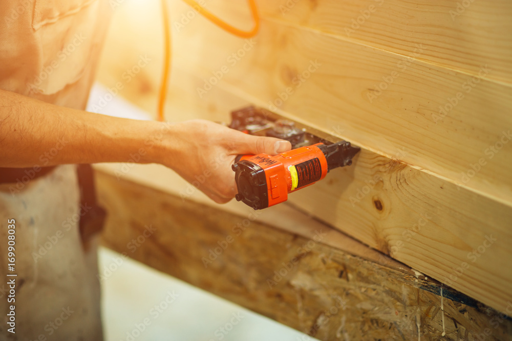 Construction worker using nail gun to nail Oriented Strand Board ...