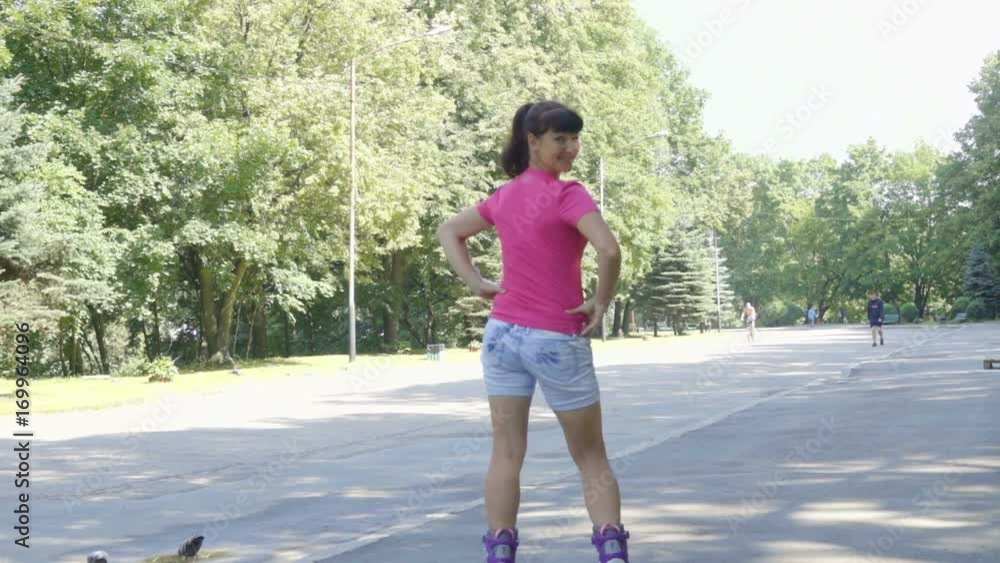 Back view of a girl in shorts on roller skates dances, whirls your ass ...