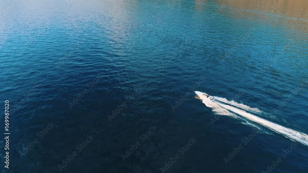 Bird eye view of luxurious speed boat sailing on the turquoise lake. It ...