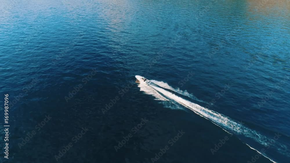 Bird eye view of luxurious speed boat sailing on the turquoise lake. It ...