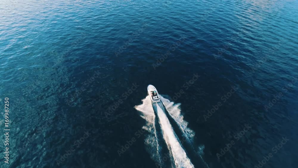 Bird eye view of luxurious speed boat sailing on the turquoise lake. It ...