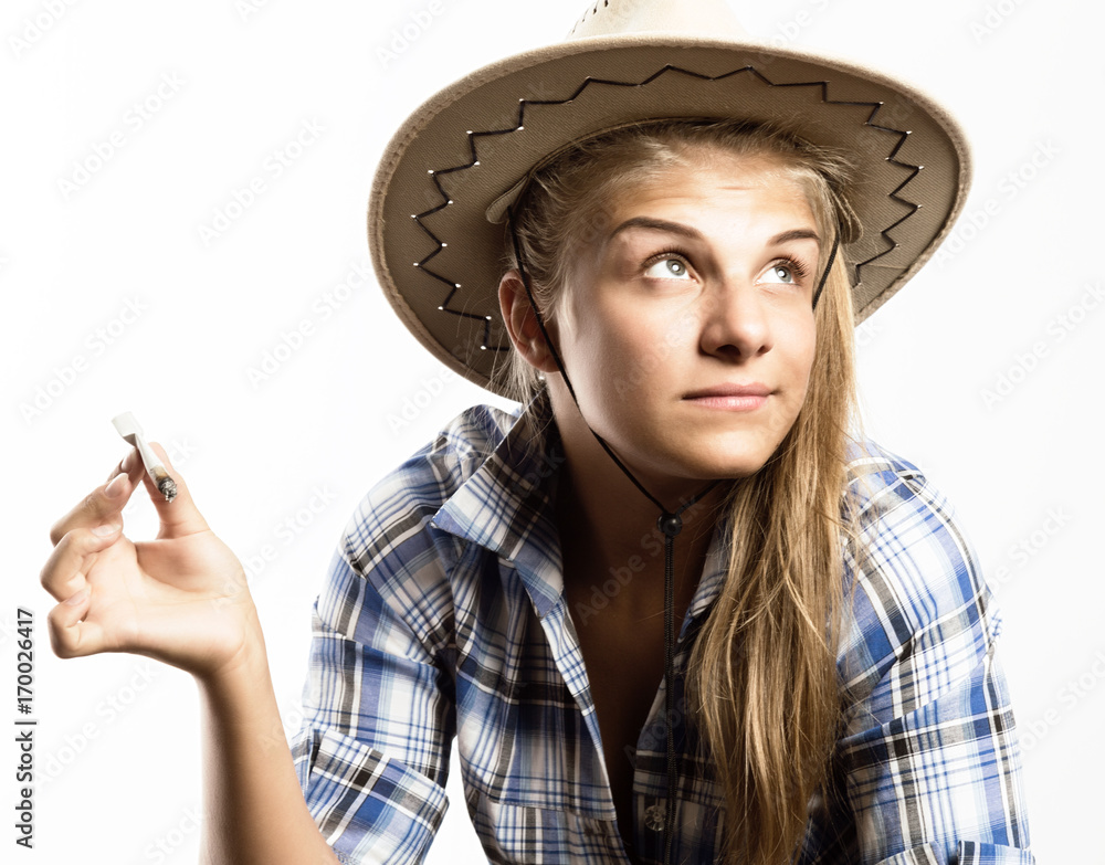 Young beautiful woman in cowboy hat and checkered shirt smoking ...