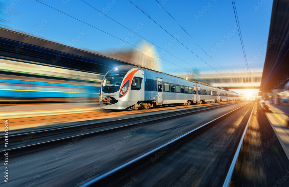 High speed train in motion at the railway station at sunset in Europe ...