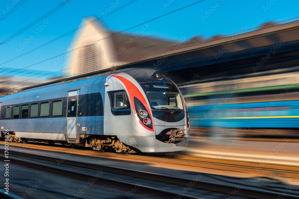 High speed train in motion at the railway station at sunset in Europe ...