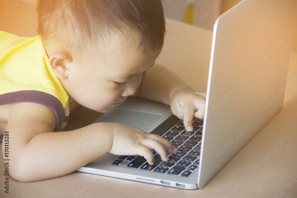 Children are using their hands to type on the Keyboard of the notebook ...