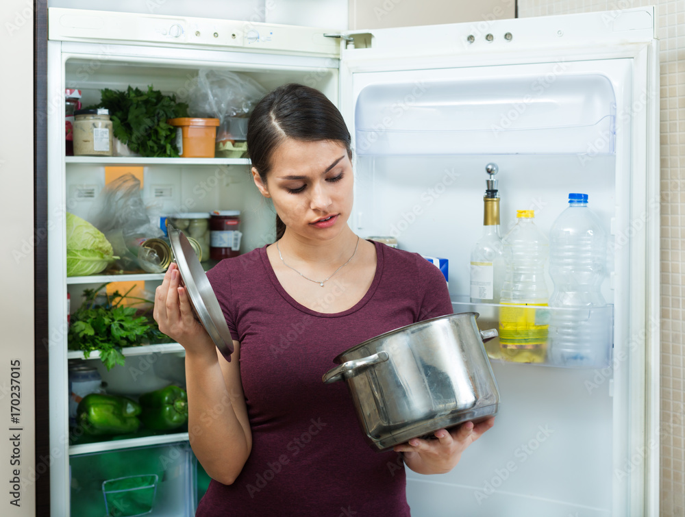 Angry and upset housewife looking into pot with foul meal Stock Photo ...
