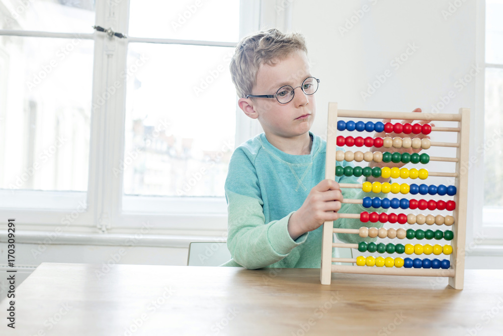 Boy calculating with abacus Stock Photo | Adobe Stock