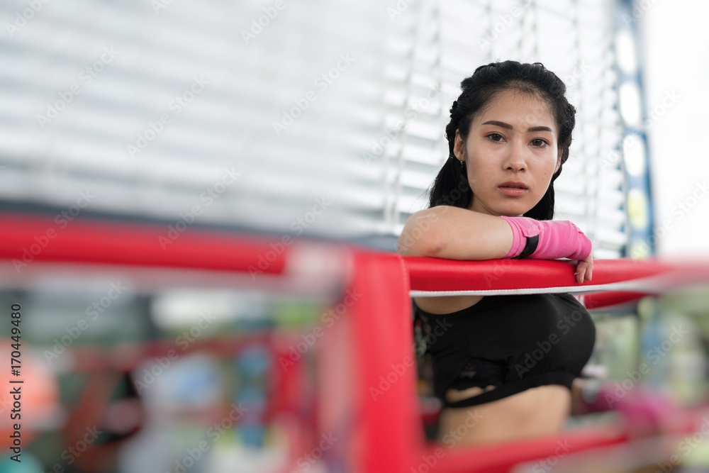 young woman prepare for exercise in fitness center. female boxer posing ...
