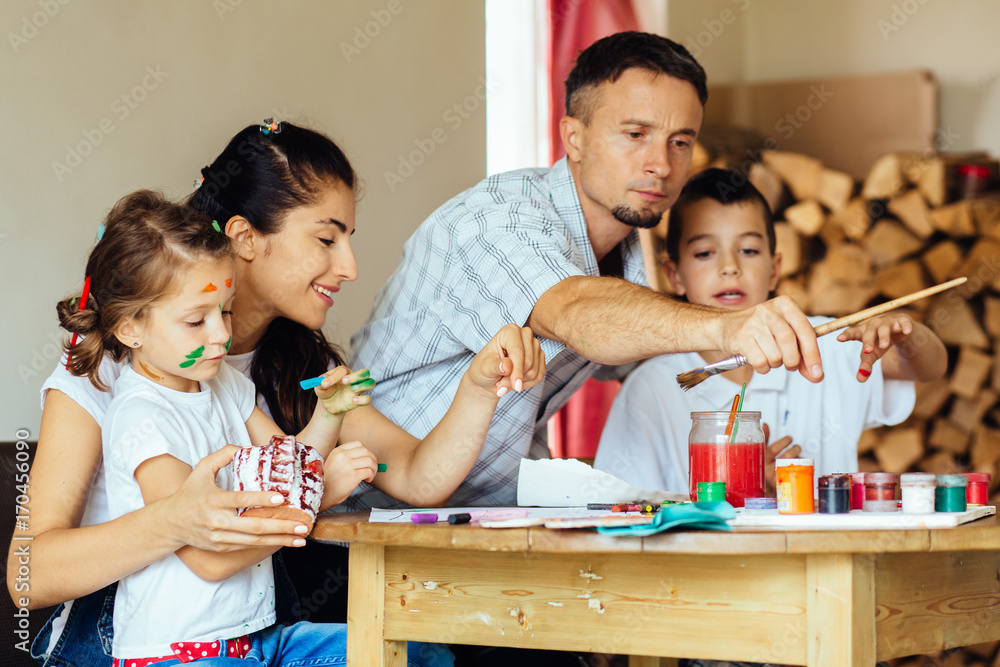 Family with two kids painting together at home, happy mother, father ...