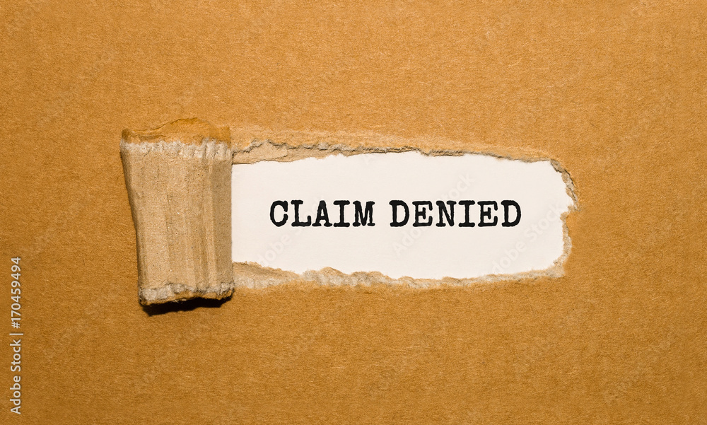 The text CLAIM DENIED appearing behind torn brown paper Stock Photo ...