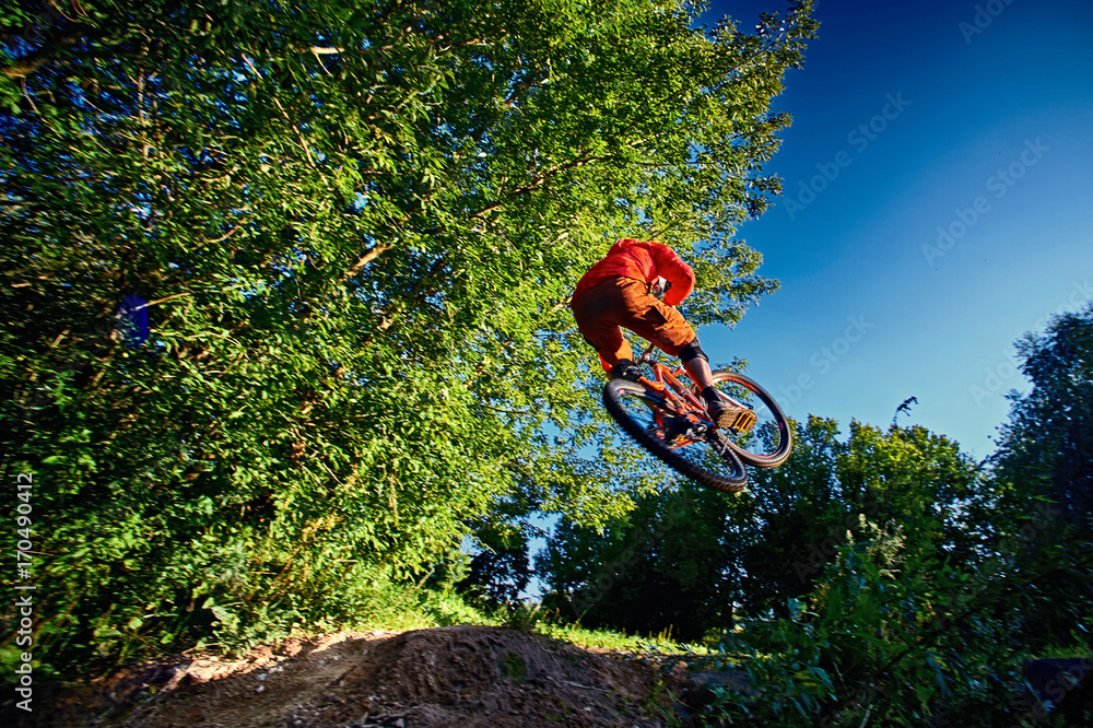 Jump and fly on a mountain bike. Rider in action at mountain bike sport. Biker riding in nature ...