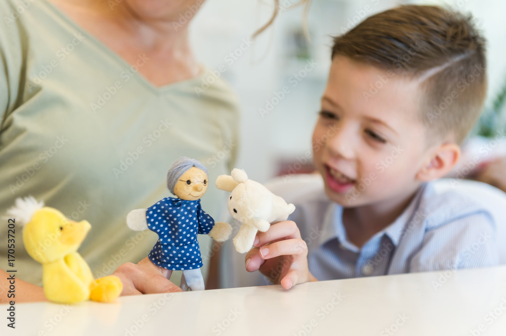 teacher woman playing with child boy with finger puppets in the ...