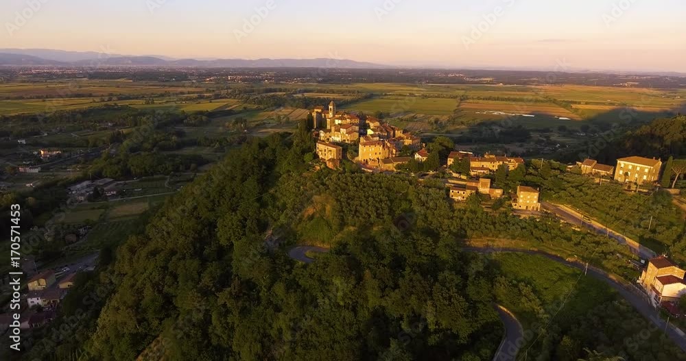 Aerial footage, a little town on the hill in the middle of woods in ...