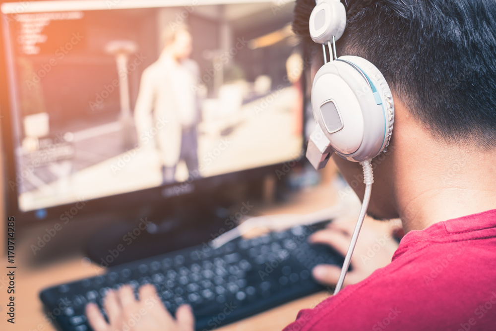 The abstract image of the asian gamer playing video game by the desktop ...