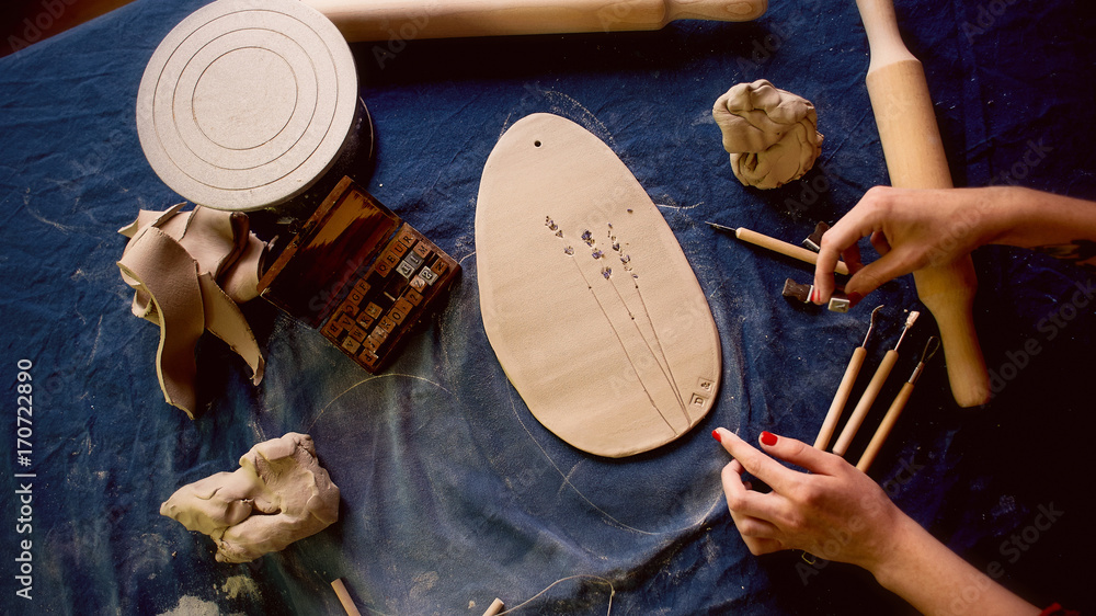 master shapes pottery on a blue canvas. Creative process. Gives shape ...