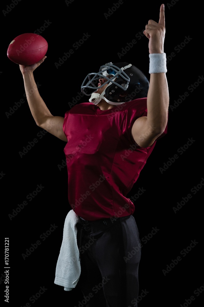American football player raising hands holding a ball high in Stock ...