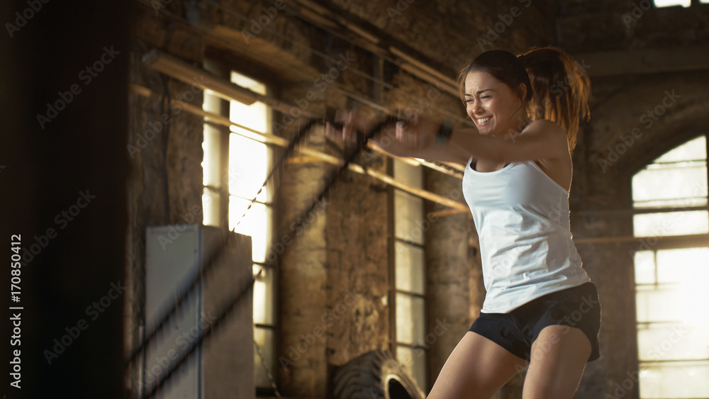 Athletic Female in a Gym Exercises with Battle Ropes During Her Cross ...