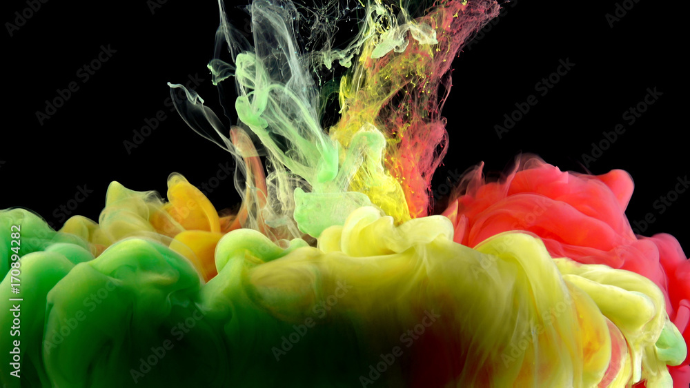 Colorful rainbow paint drops from above mixing in water. Ink swirling ...
