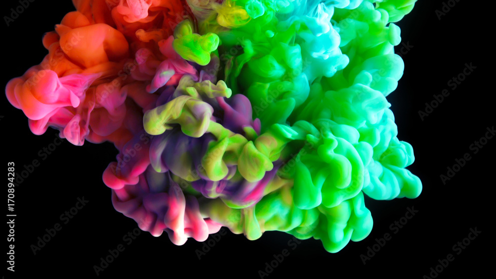 Colorful rainbow paint drops from above mixing in water. Ink swirling ...