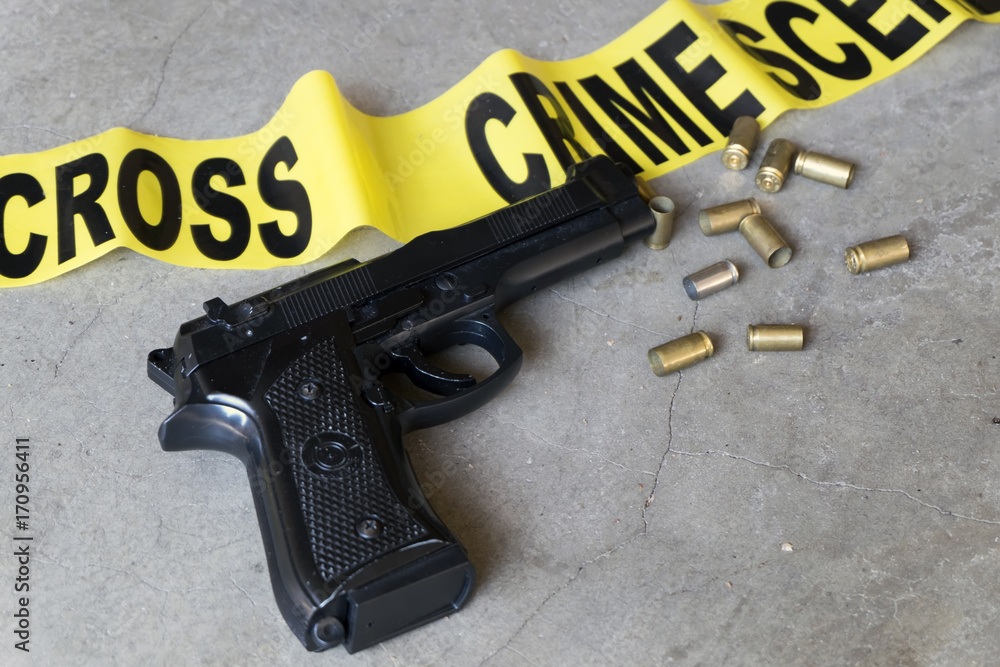 Crime scene concept with black gun and crime scene tape from above ...