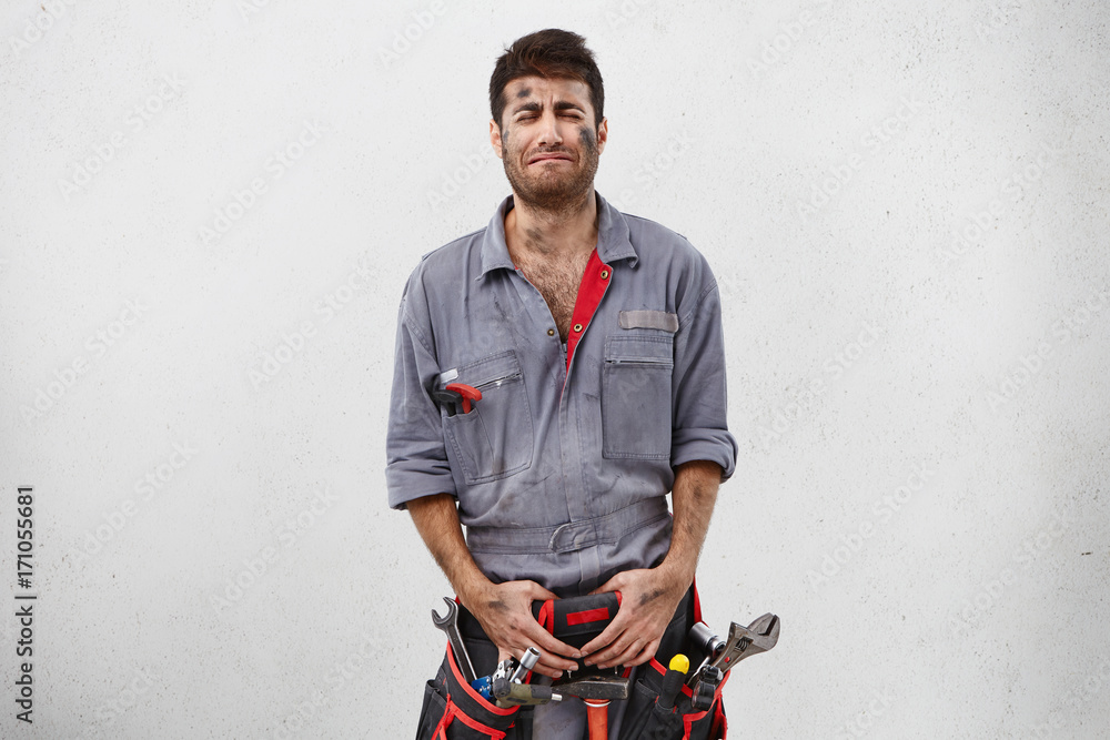 Portrait of male mechanicer, having sorrorful expression while not ...
