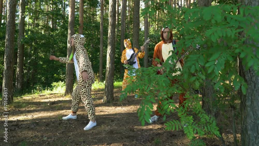 Mad people in animals costumes dances, jumps, have fun in forest on ...