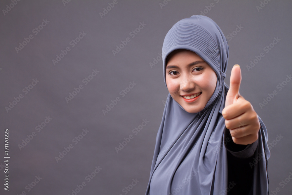 muslim woman with hijab pointing thumb up Stock Photo | Adobe Stock