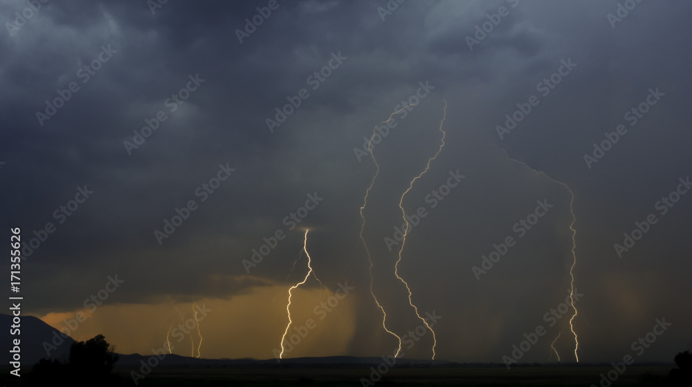 Cloudy sky with visible lightnings while raining at mountain landscape ...